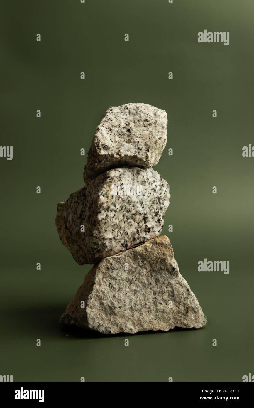 granite stones stacked on a green background Stock Photo - Alamy