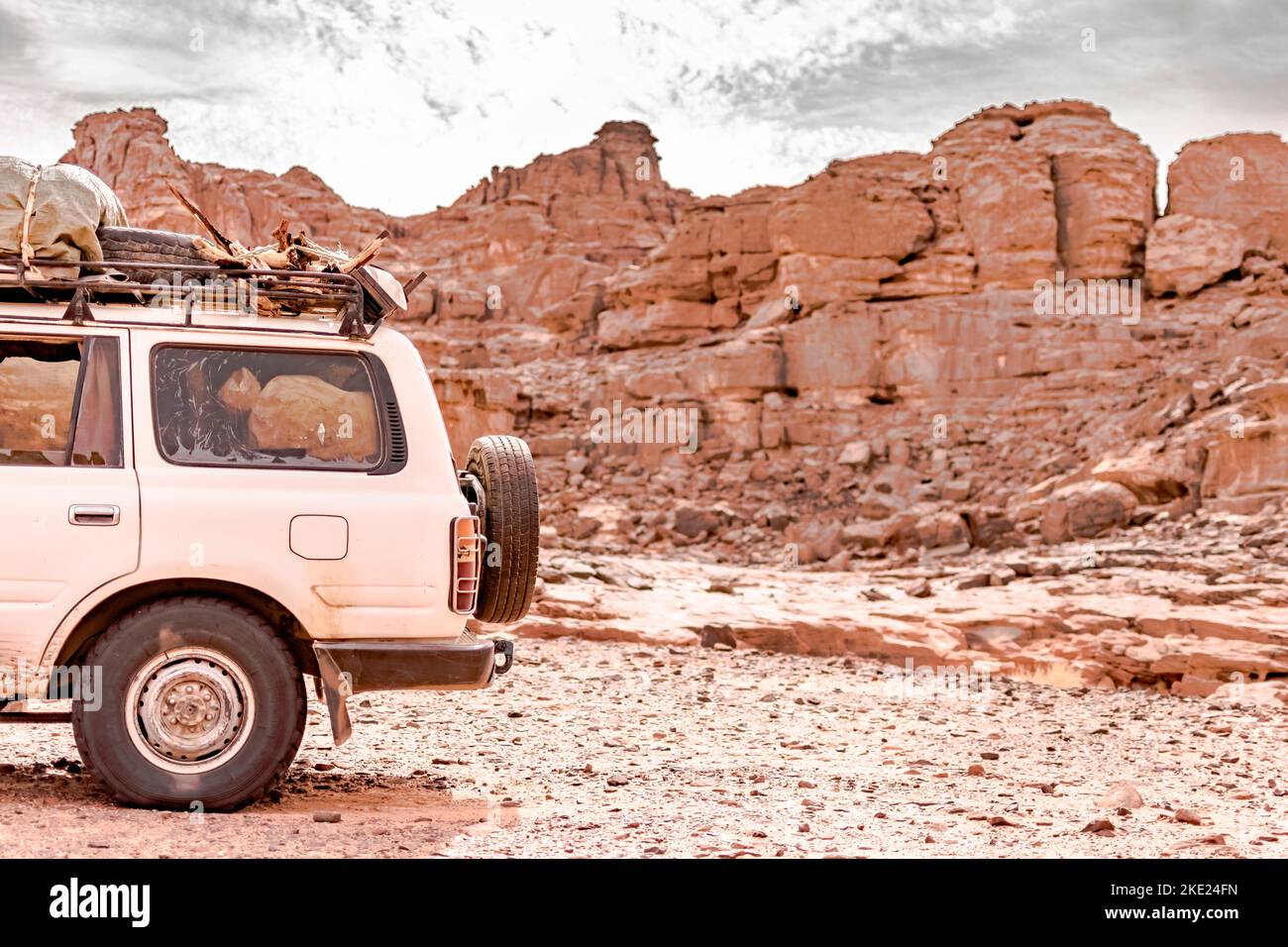 Rear side view of a 4x4 car loading package and wood in the Sahara ...