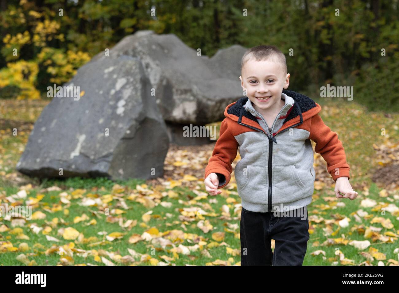 a child at a park running towards the camera smiling Stock Photo - Alamy