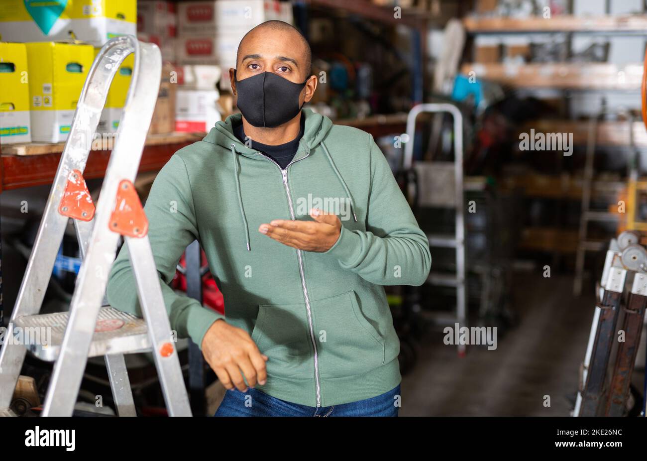 Buyer in protective mask chooses stepladder at hardware store Stock ...