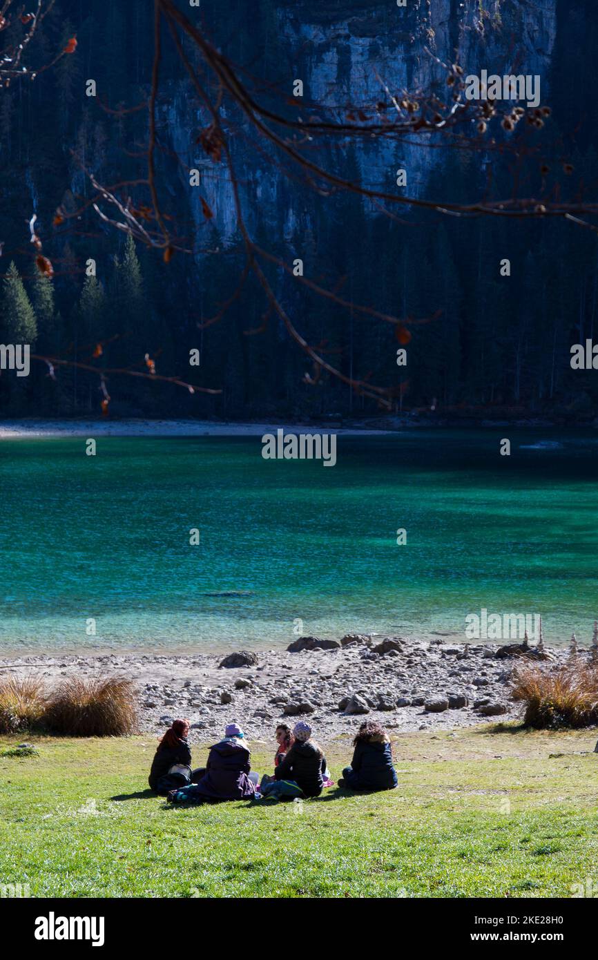 Some people, not recognizable, sitting near the crystal clear waters of ...