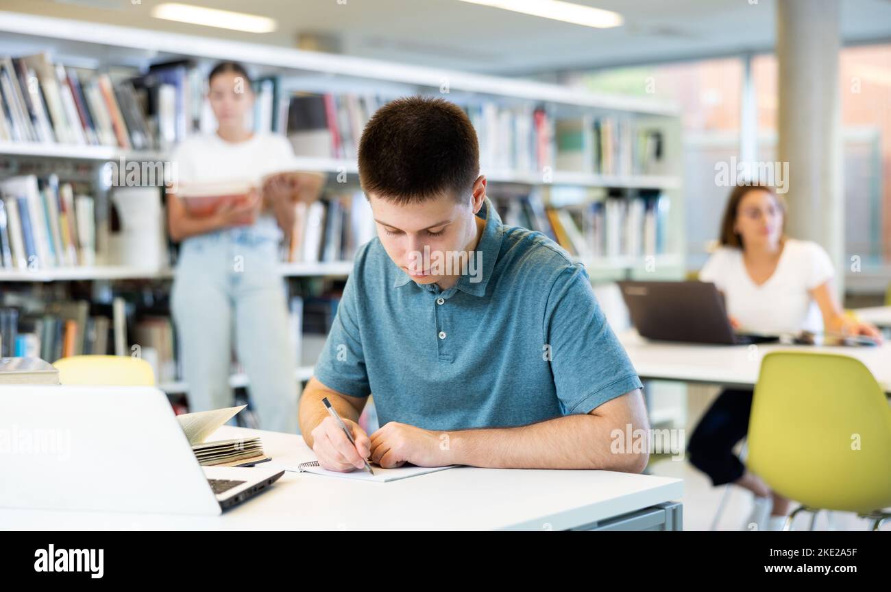 Concentrated young man checking plans in calendar while studying in the ...