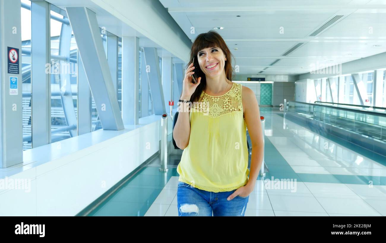 Woman standing on Automatic walkway,, in subway crossing, talking ...