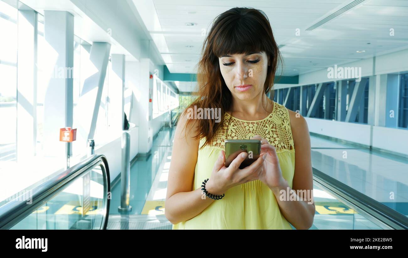 Woman standing on Automatic walkway, stairs in subway crossing, using ...