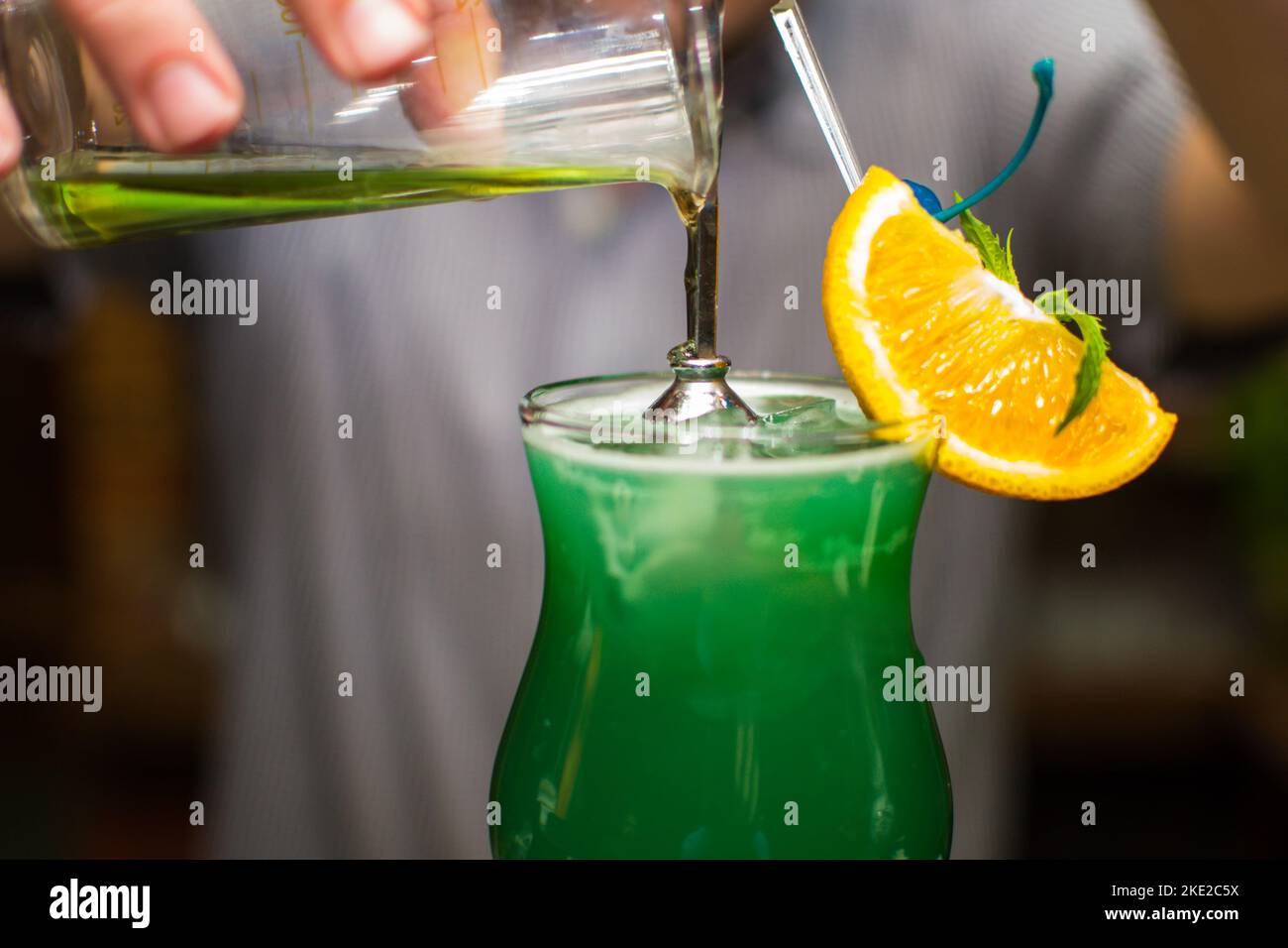 Bartender making refreshing coctail on a bar background. Dark moody ...