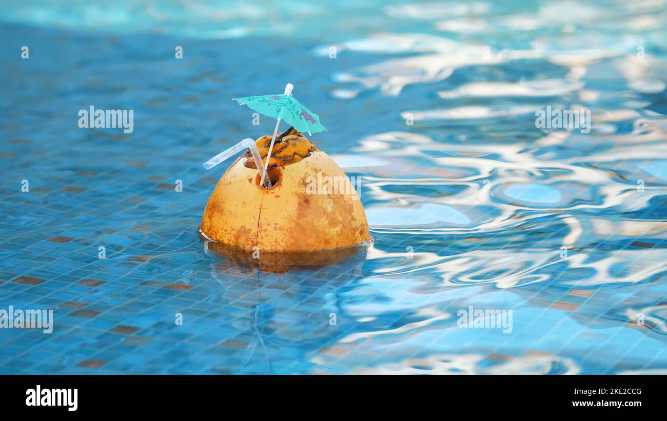 Fresh Coconut juice cocktail with drinking straw floating in a ...