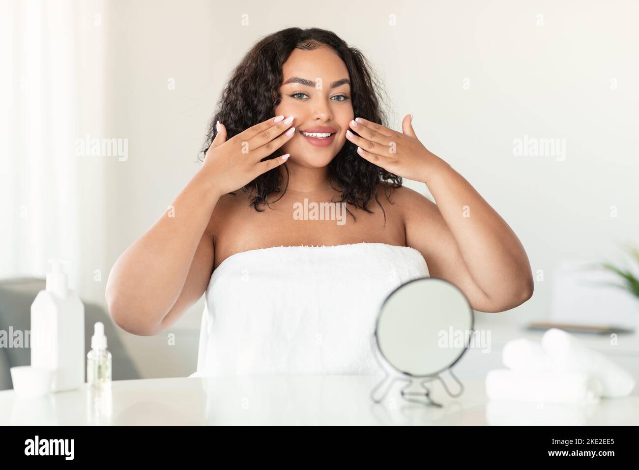 Young african american plus size lady touching her face while making ...