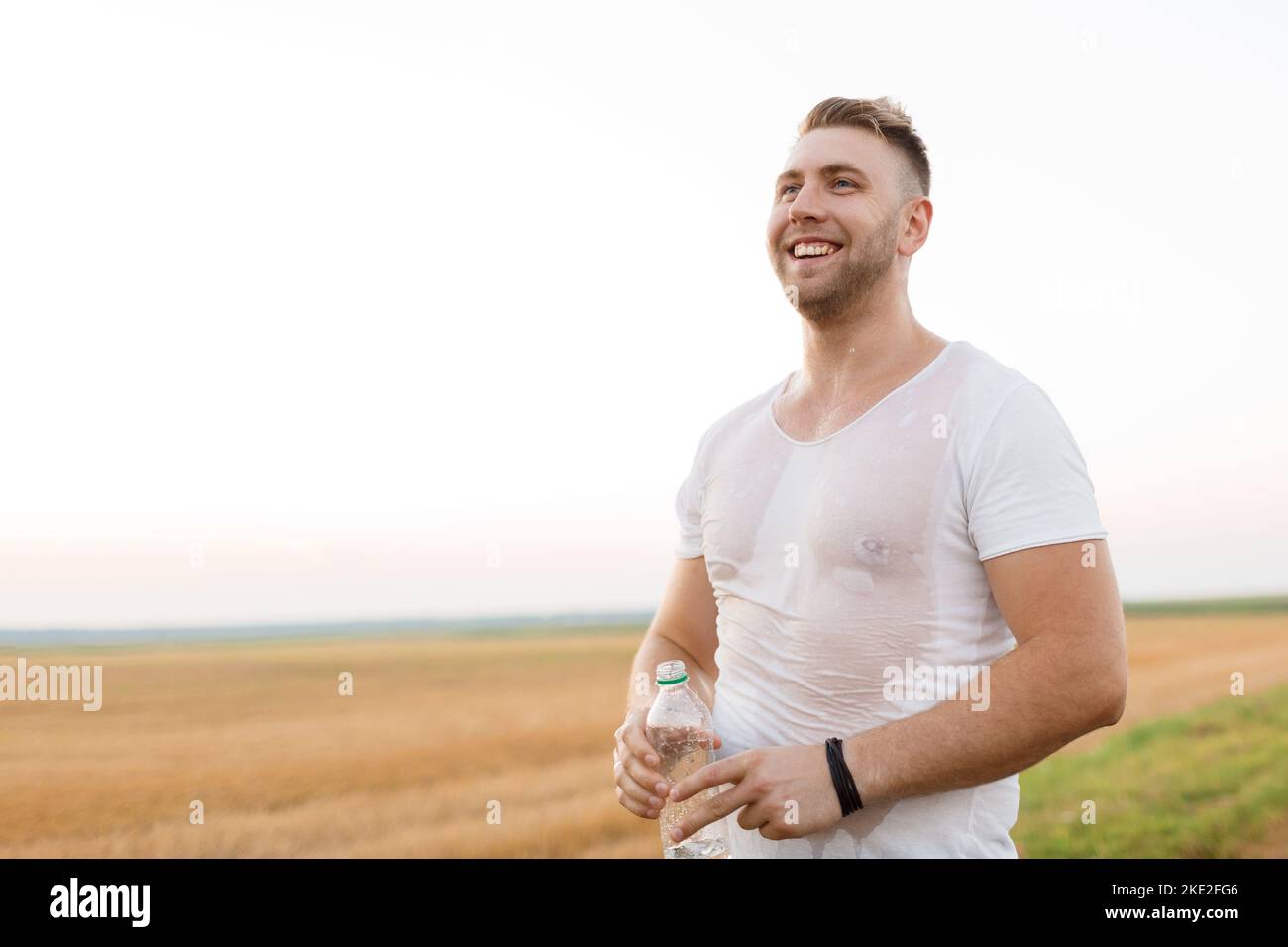Wet sporty man resting after run Stock Photo - Alamy