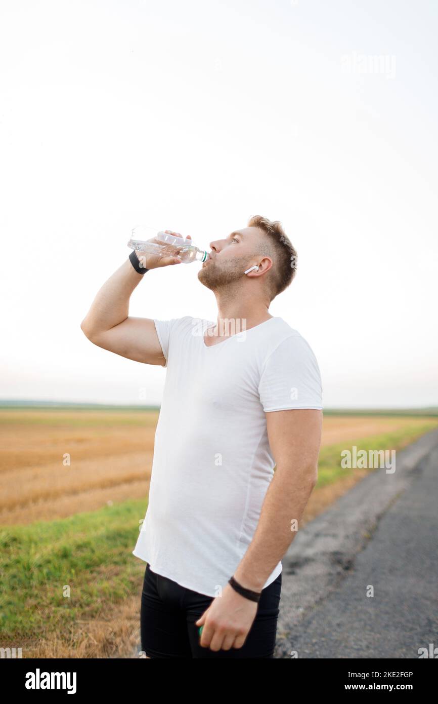 Tired runner drinking water Stock Photo - Alamy