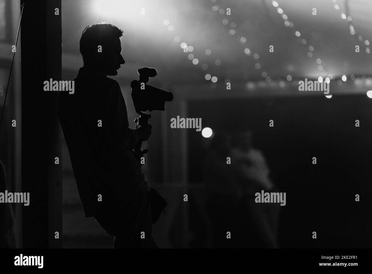 black white photo. Silhouette of cameraman standing with video action ...