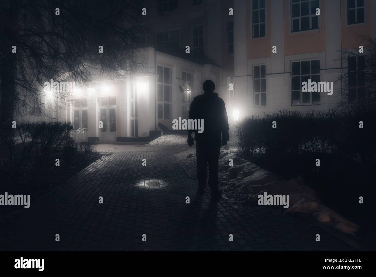 Sad man alone walking along the alley in night foggy park Stock Photo ...