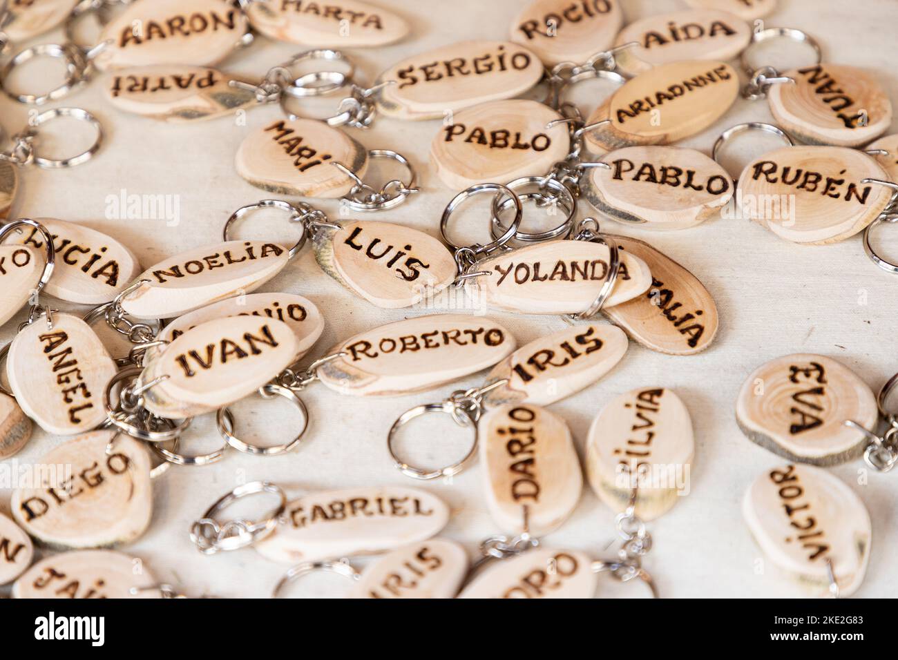 foreground of handcrafted wooden keychains engraved with proper spanish ...