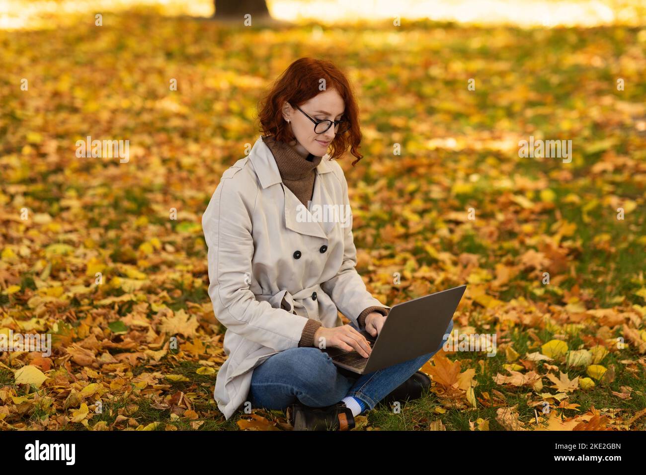 Happy smart caucasian millennial lady with red hair in raincoat and ...