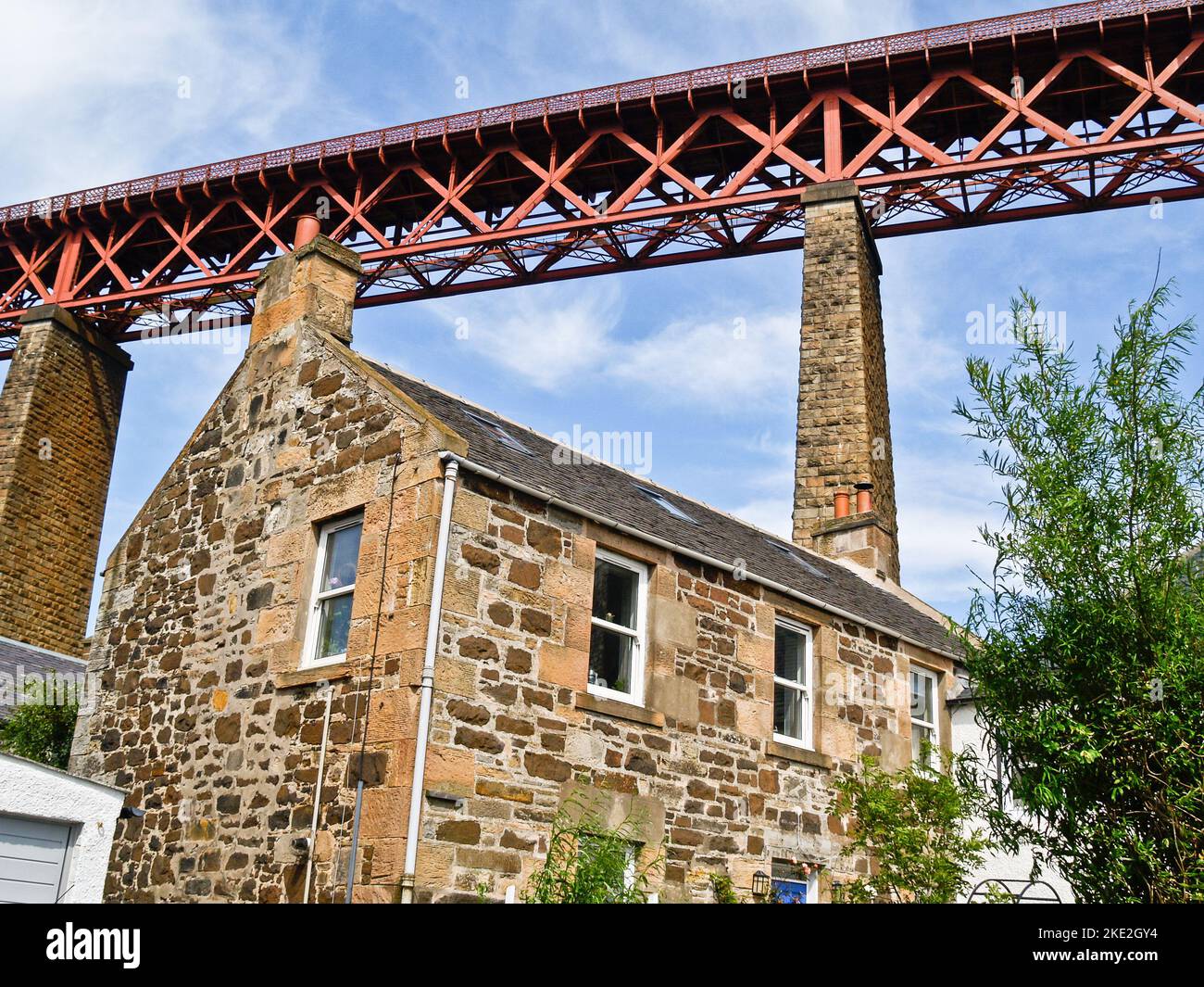 Quaint old stone cottage under red steel span of North Queensferry ...