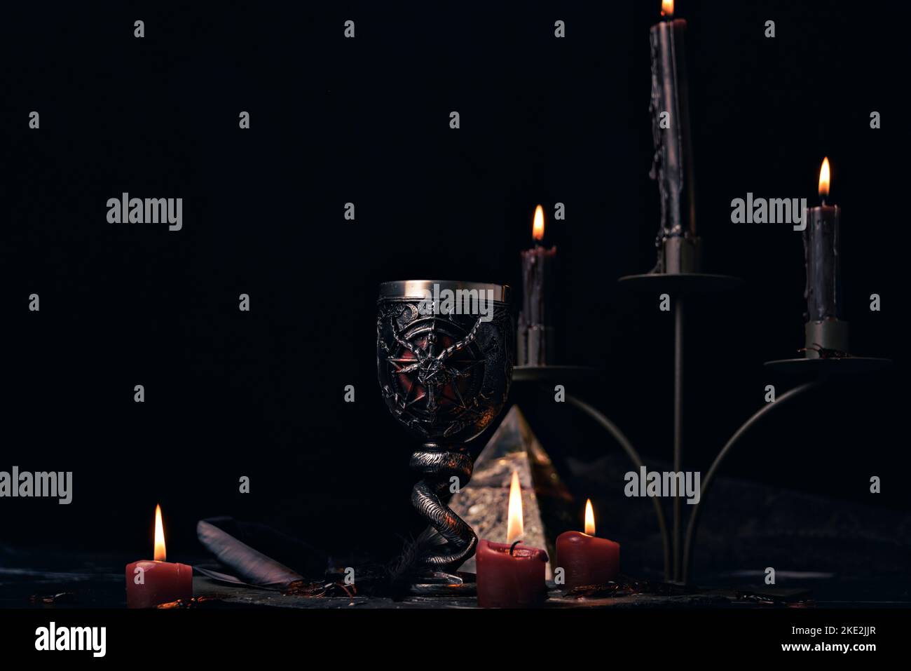 Witchcraft composition with burning candles, books, jewelry and ...