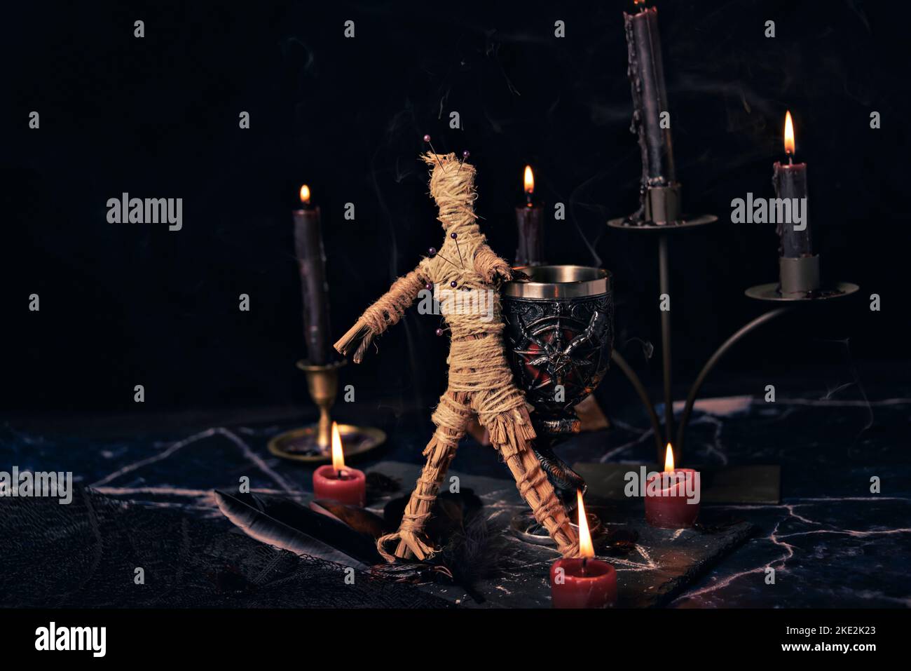 Voodoo doll in ritual scene close up, magic table with candles ...