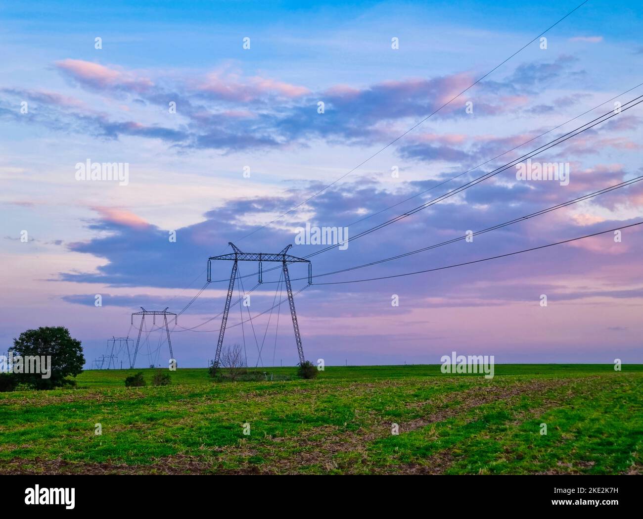High voltage electric poles, rural landscape with power pylons in a row ...