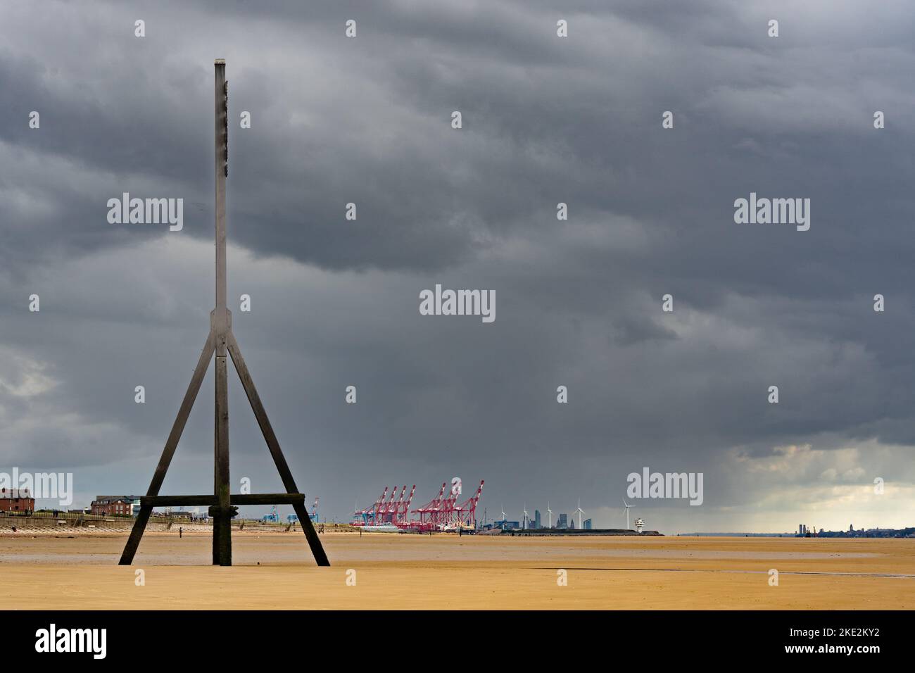 Crosby beach looking towards the port of Liverpool, with red cranes ...