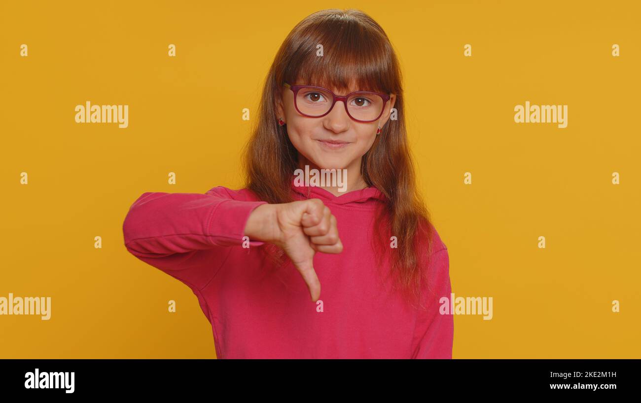 Dislike. Upset young preteen child girl kid showing thumbs down sign ...