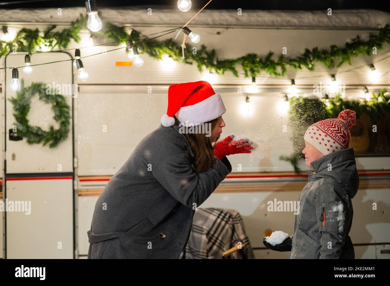 Caucasian woman playing snowballs with her son at the camper Stock ...