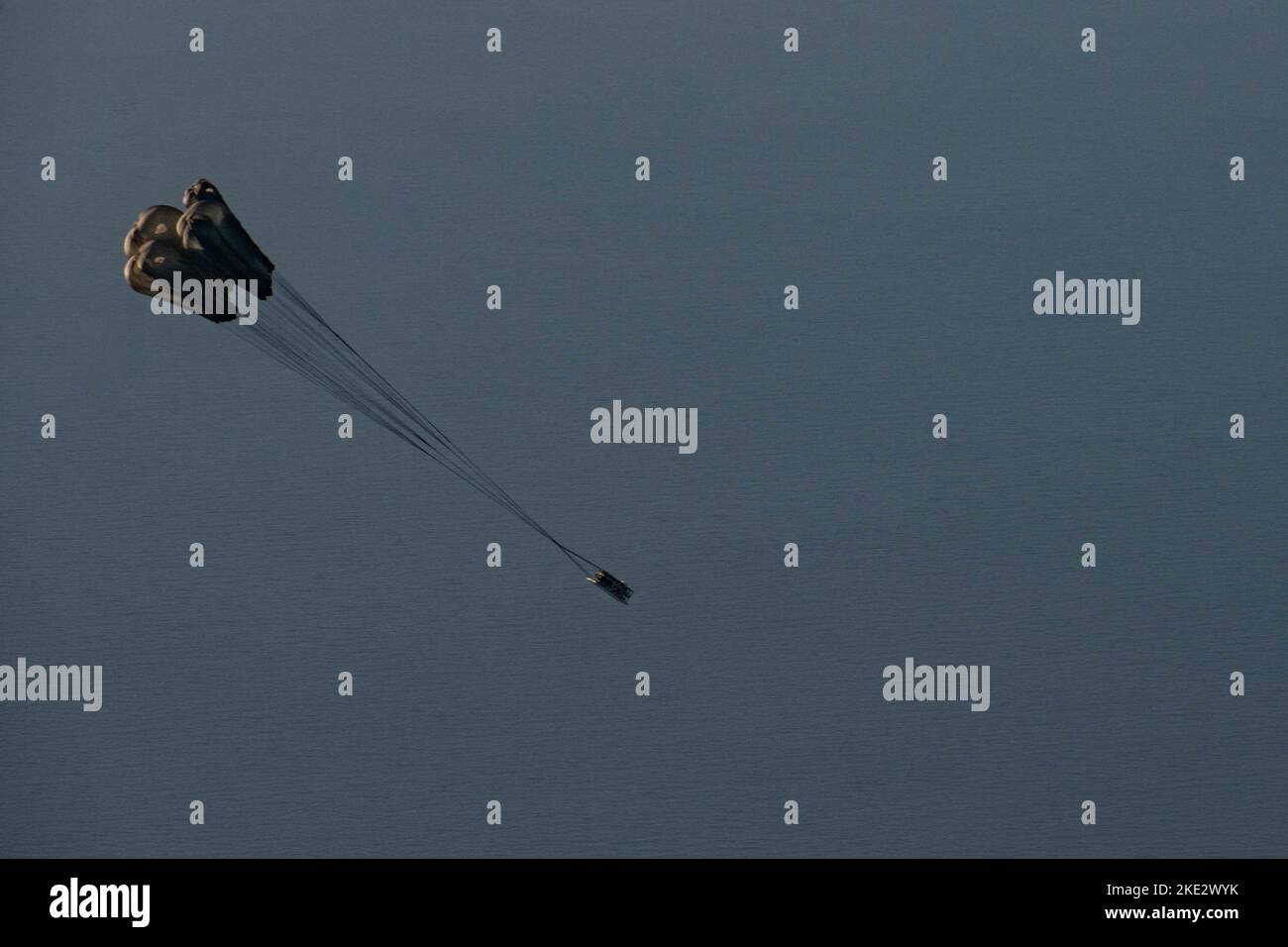 A palletized munitions system falls from the cargo hold of a 352d ...