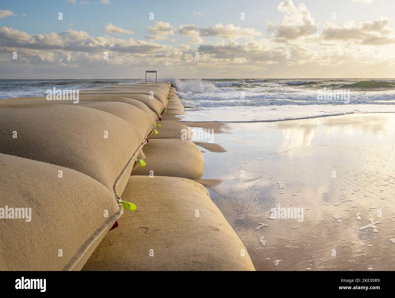 A groyne or a low geotextile sandbag wall, built out from the coastline ...