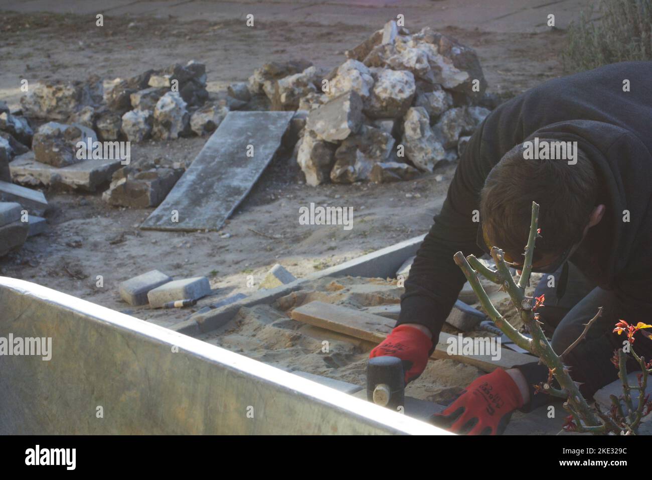 Defocus paver master. Man lays paving stones in layers. Garden brick ...