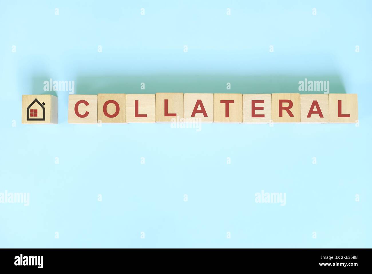 Collateral concept in real estate. Wooden blocks typography on blue ...