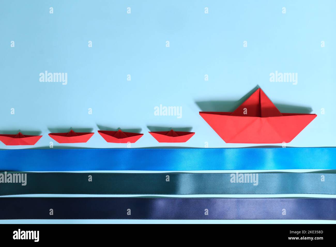 Good leadership business concept. Big paper boat leading a group on ...