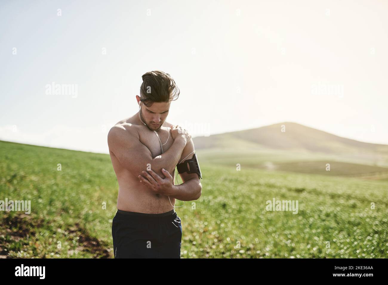 Feeling it in his elbow. Rearview shot of a young man holding his elbow ...