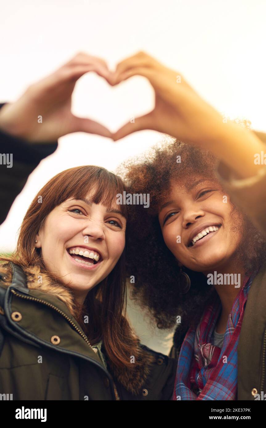 Two friends, one heart. two friends making a heart shape with their ...