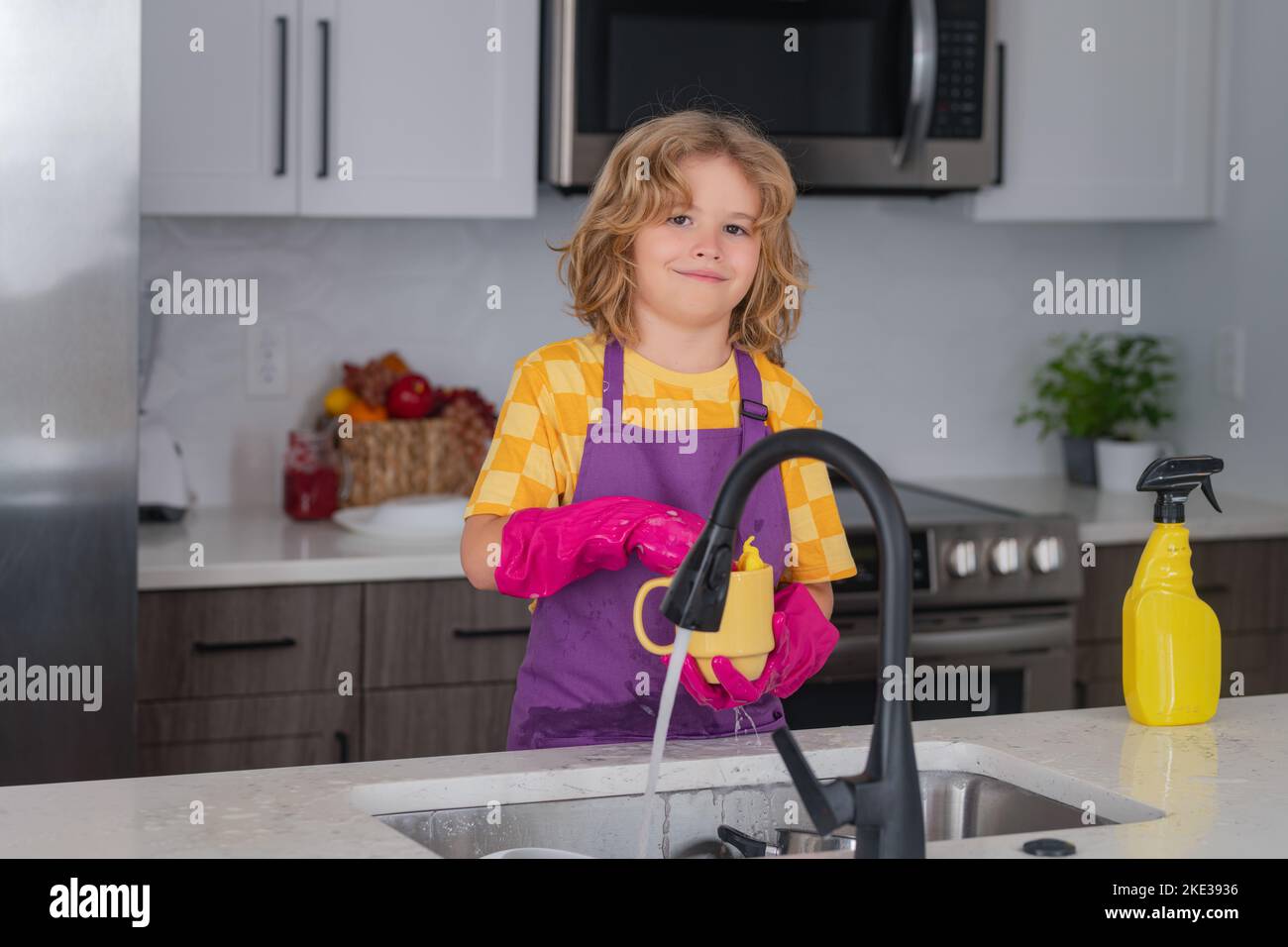 Clean dishes. Child doing and wiping dishes in kitchen. Little kid ...
