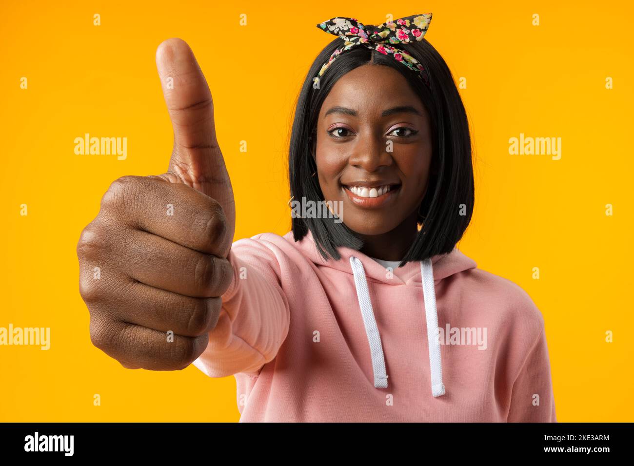 African young woman over isolated yellow background with thumbs up ...