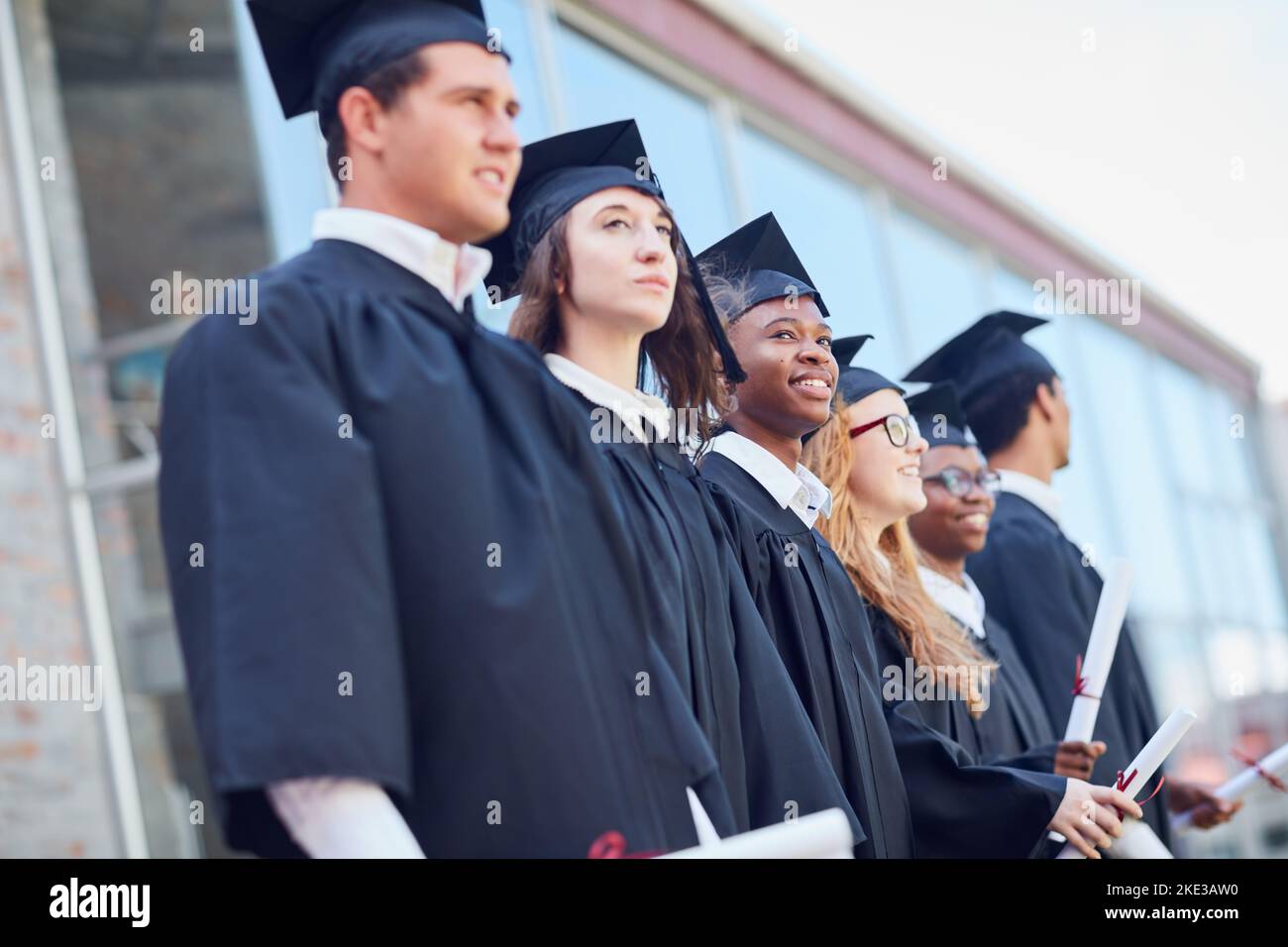 Standing tall at their graduation. a happy group of students standing ...