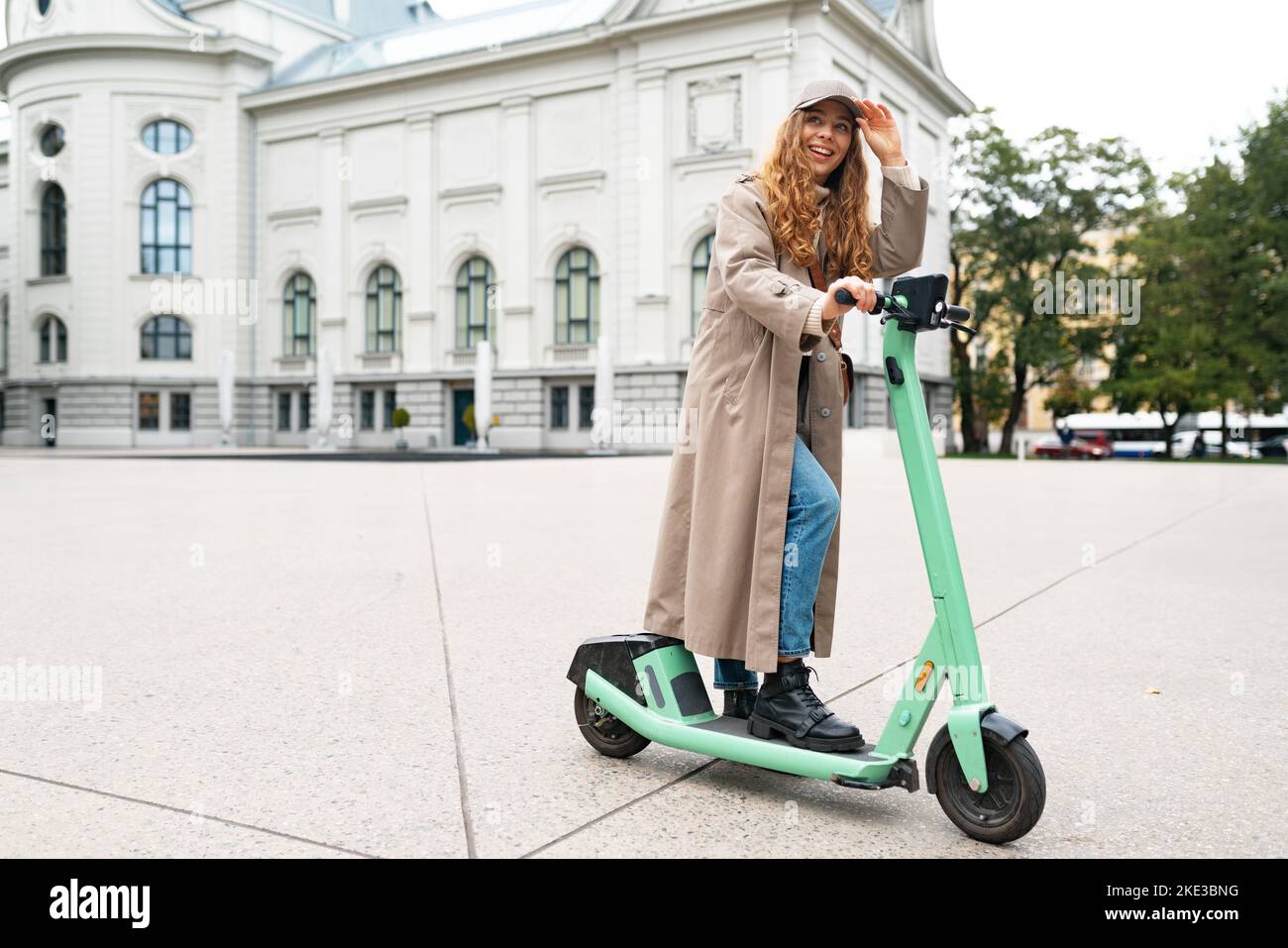 Young blonde woman riding a kick scooter in city street Stock Photo - Alamy
