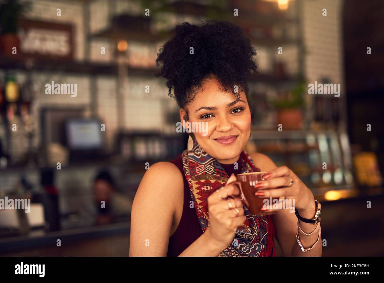 Enjoying a perfect afternoon pick-me-up. Portrait of an attractive young woman enjoying a cup of ...