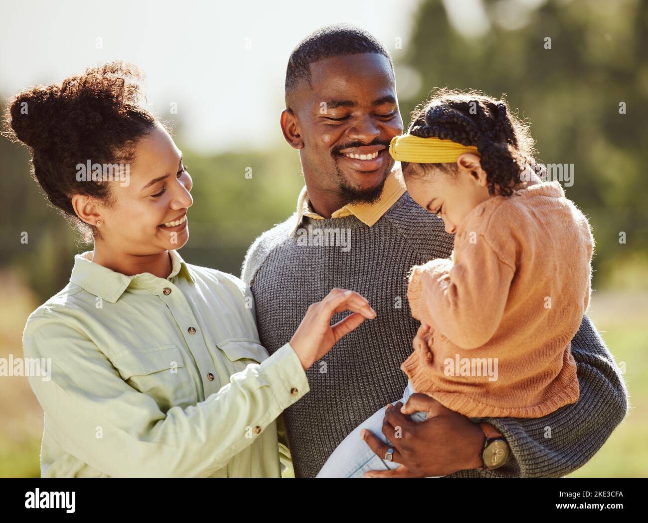 Love, family and happy girl with parents in a park, laughing and ...