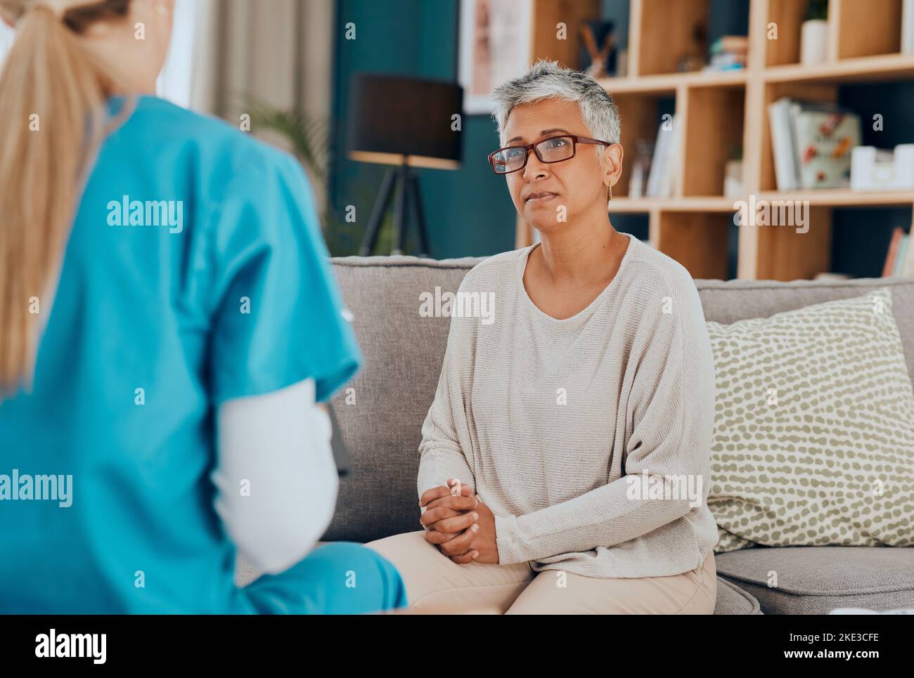 Nurse, senior woman and consultation on sofa in home for health check ...