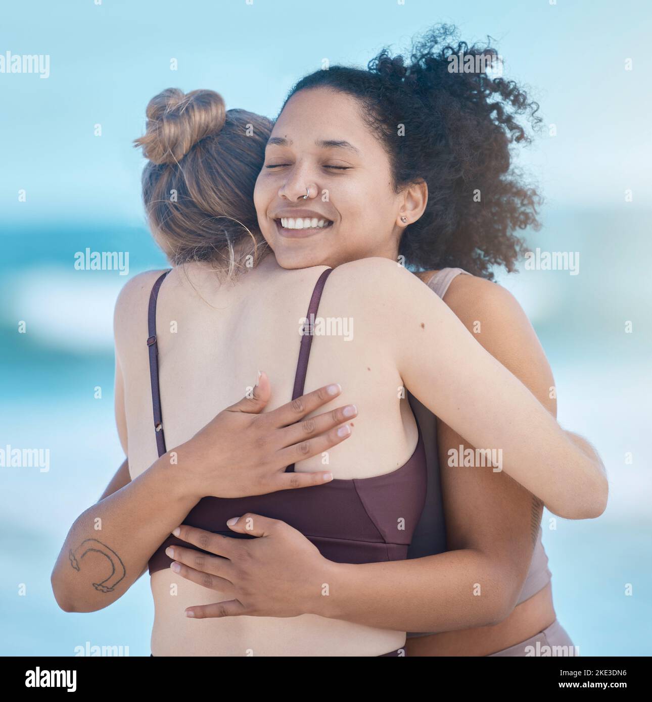 Friends, women and hug after exercise outdoor, happy and calm at the beach with love and fitness ...