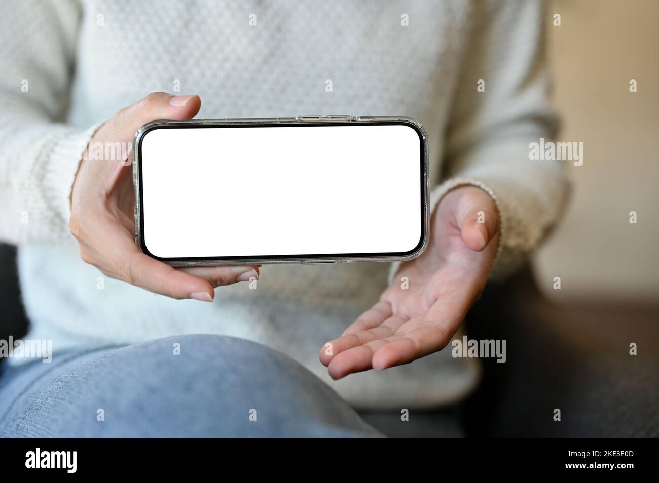 An Asian woman in casual clothes showing her smartphone white screen ...