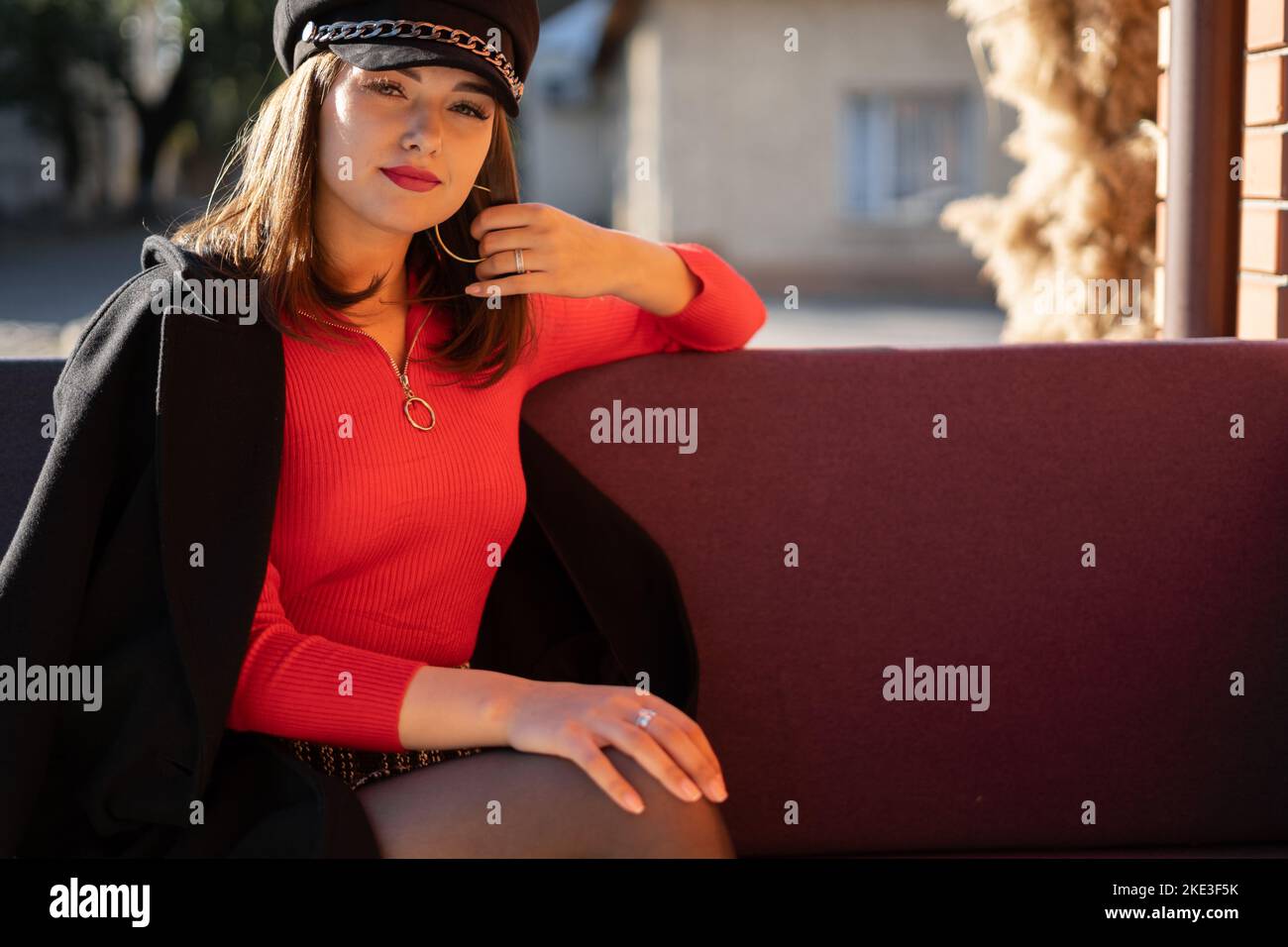 Charming girl with red lips, wearing stylish hat, black coat posing in ...