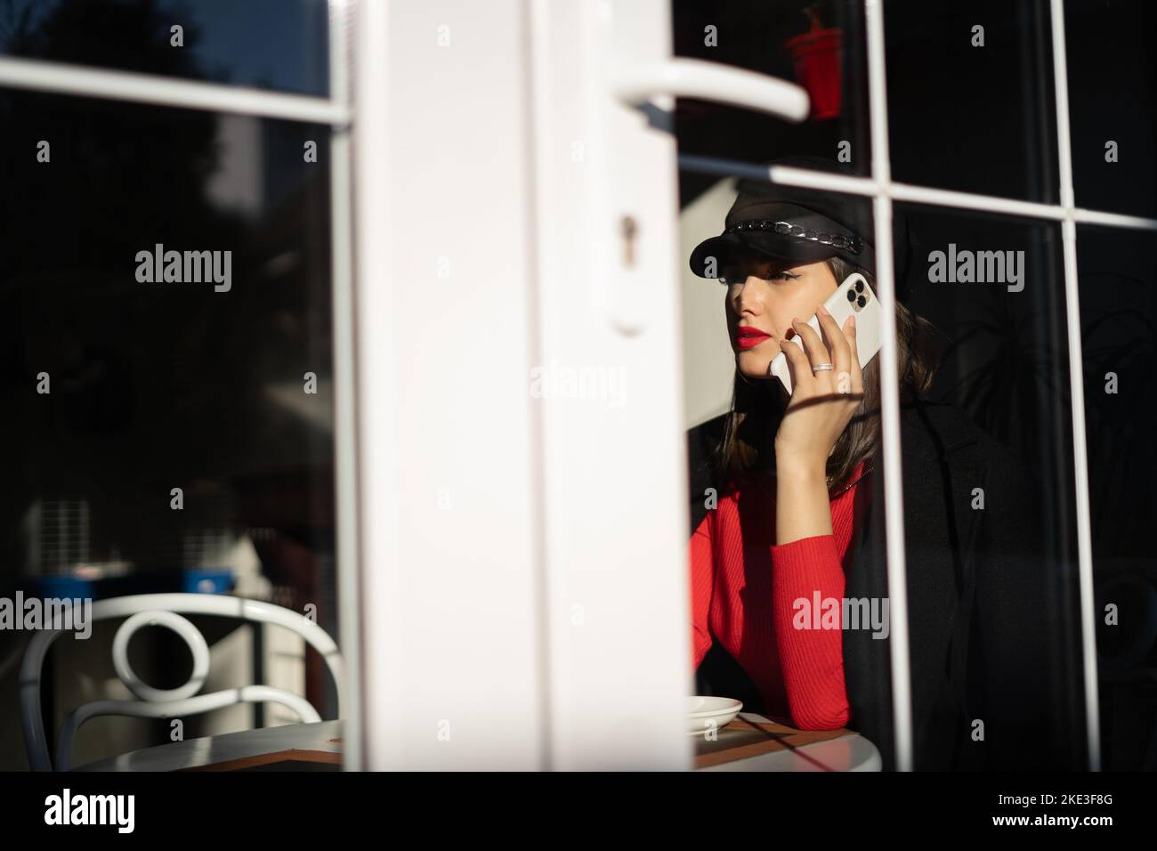 Woman Talking On A Mobile Phone While Sitting In A Cafe View Through