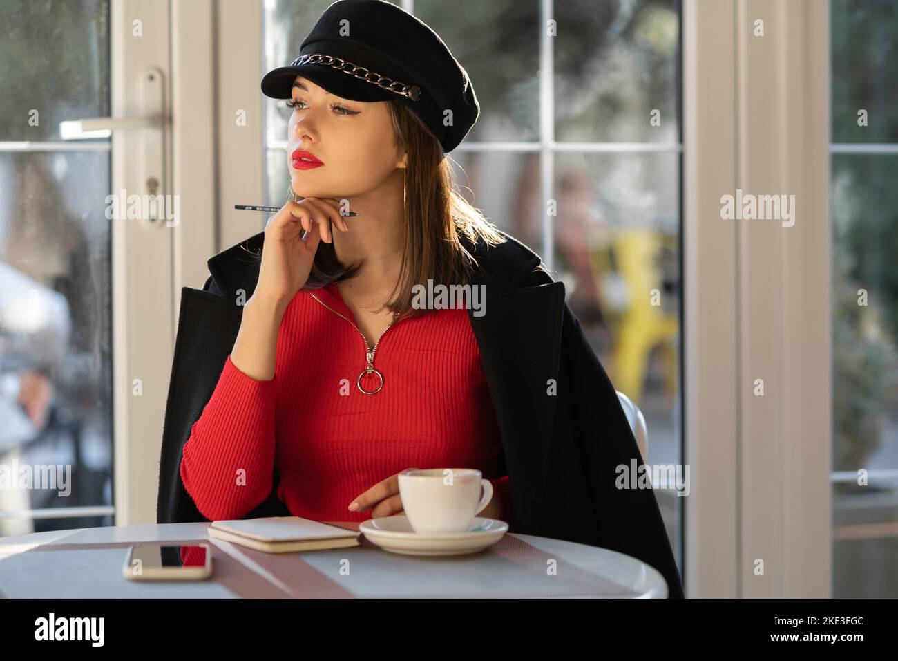 pensive young female writer looking away and thinking while working on ...