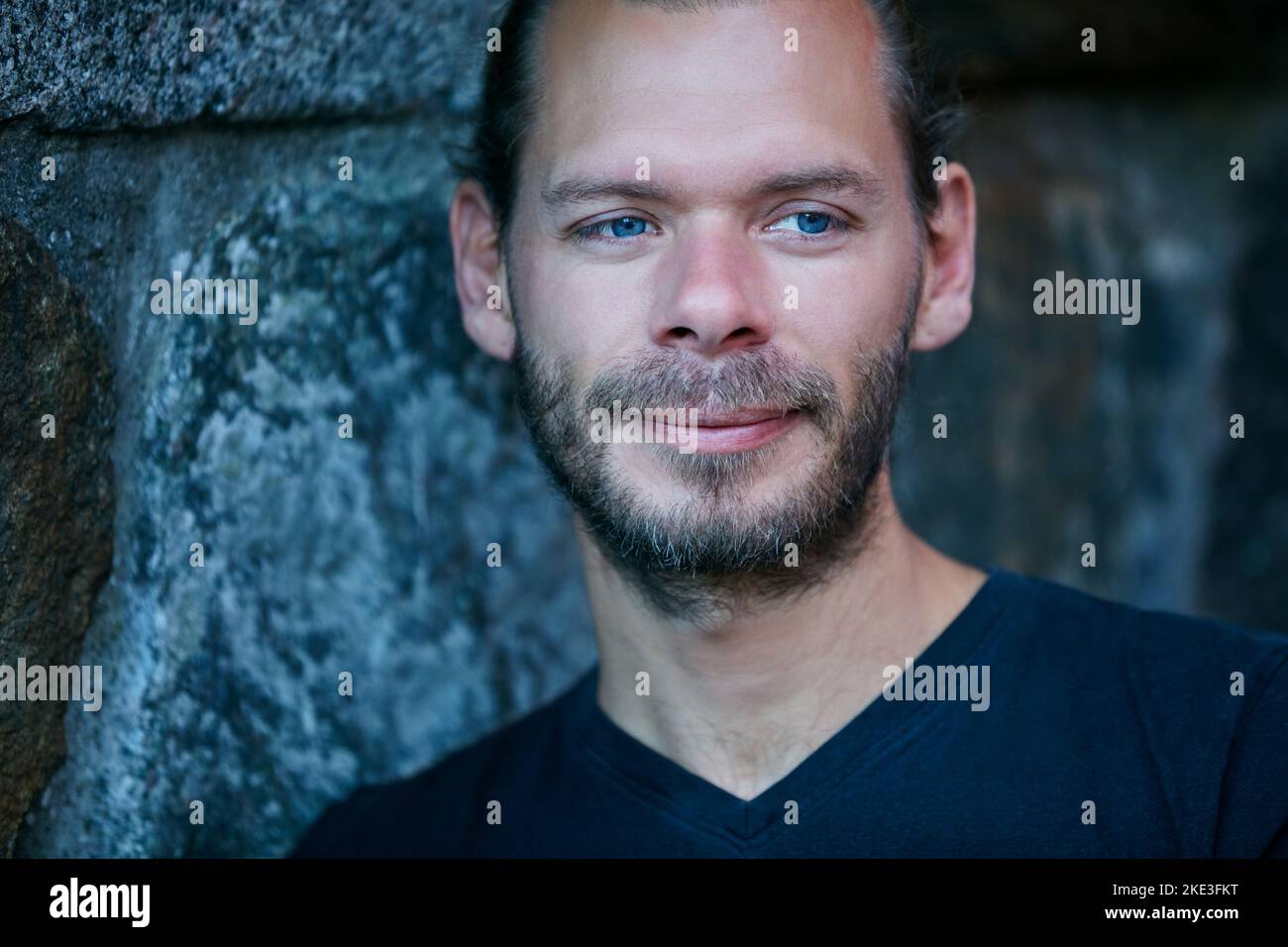 Putting out positive vibes. a man leaning against a wall outside Stock ...