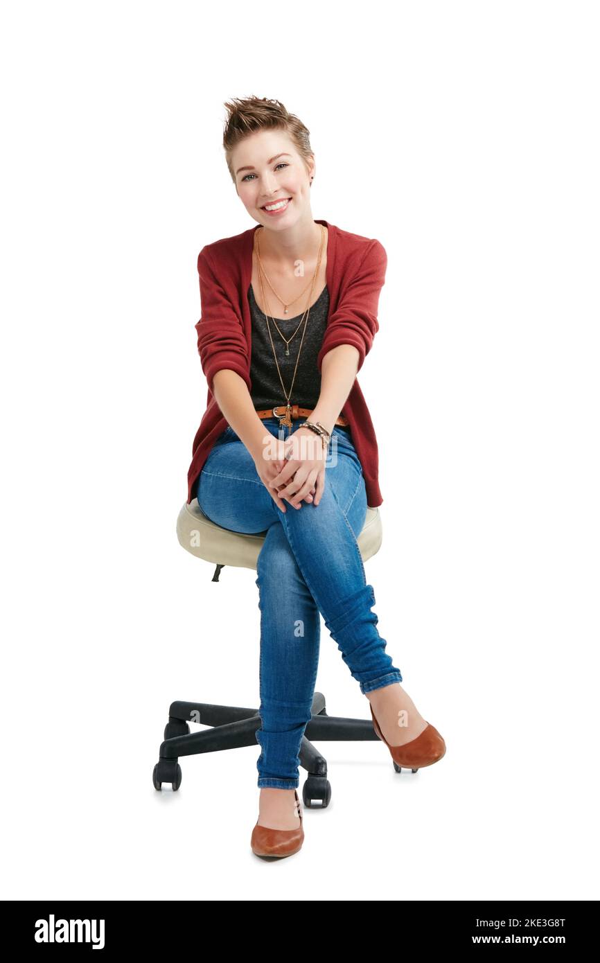 Style kept casual. Studio portrait of a happy young woman sitting on a ...