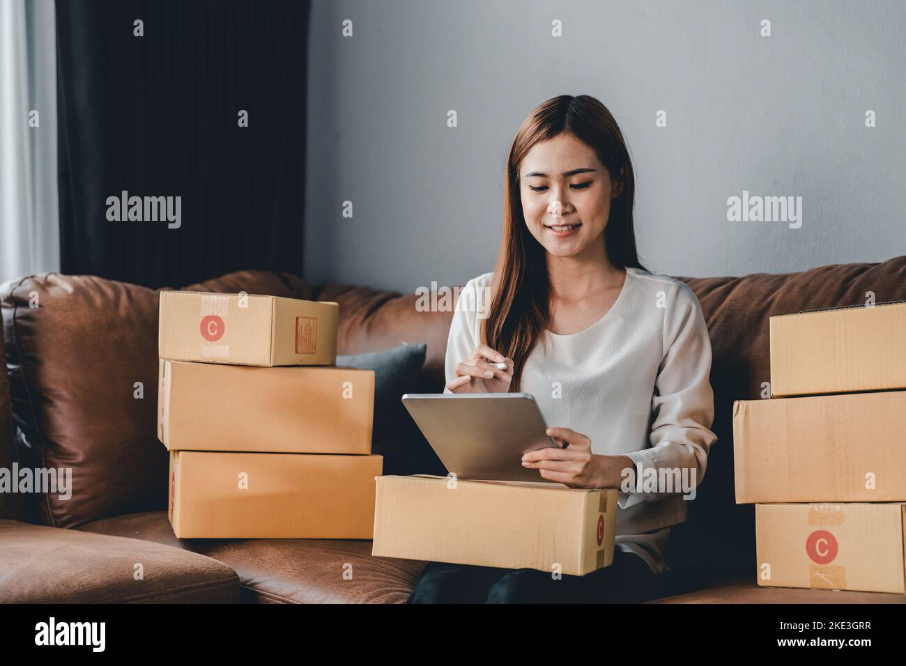 Asian female with small stock business owner holding digital tablet and ...