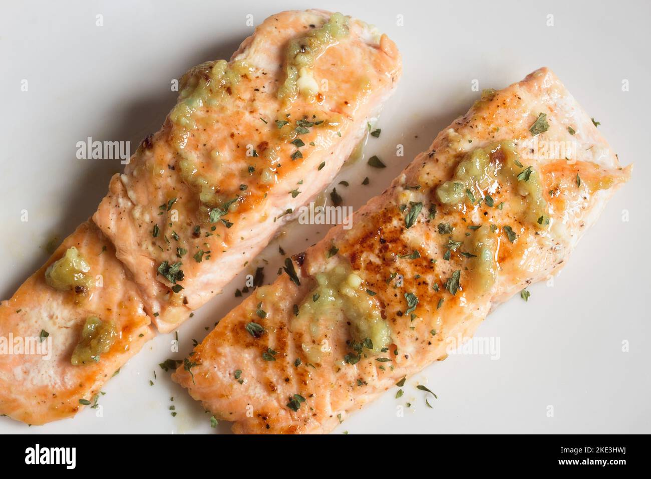 Overhead view of two lemon salmon loins with garlic and spices on a ...