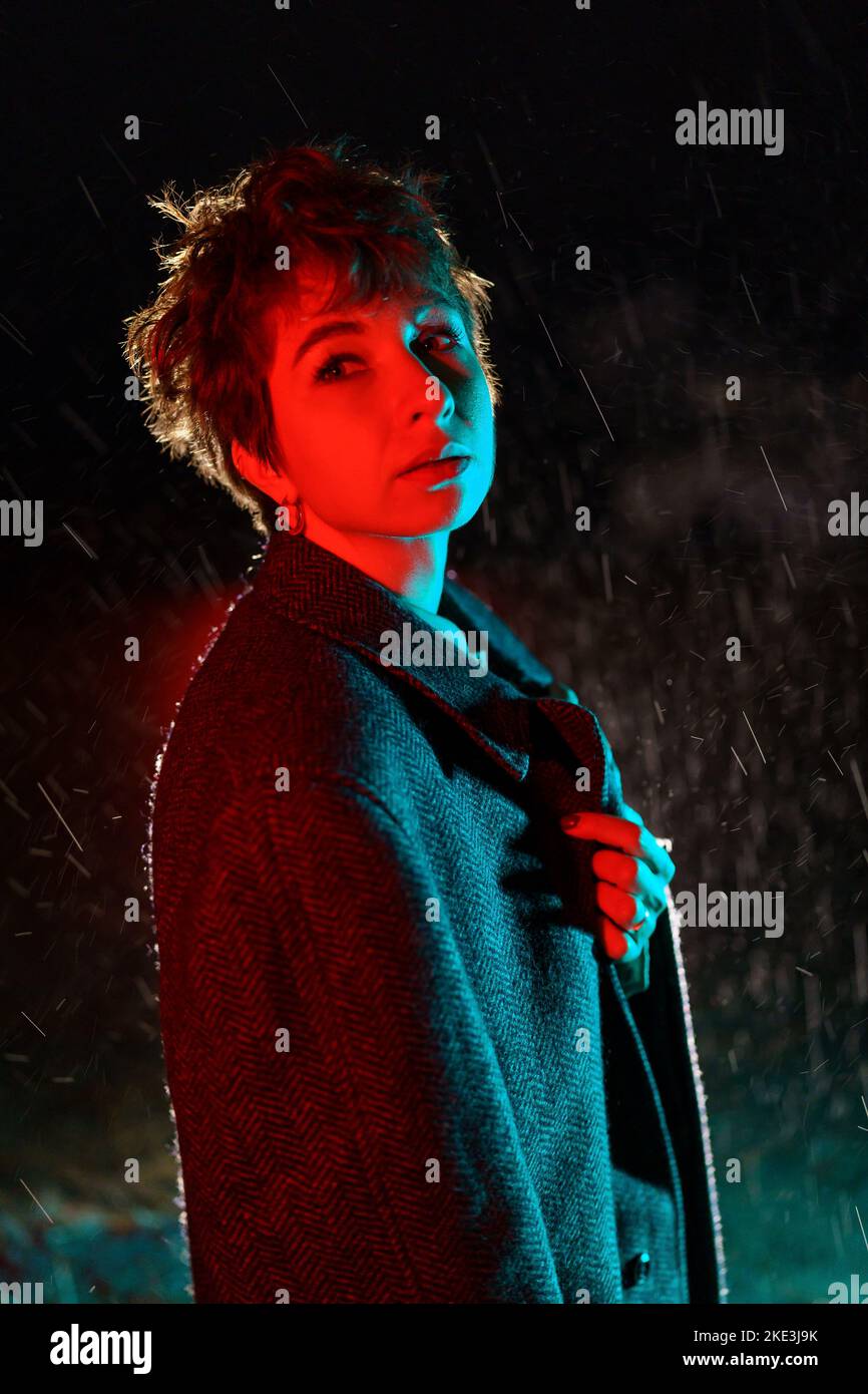 Frozen Caucasian woman as with coat draped over shoulders posing ...