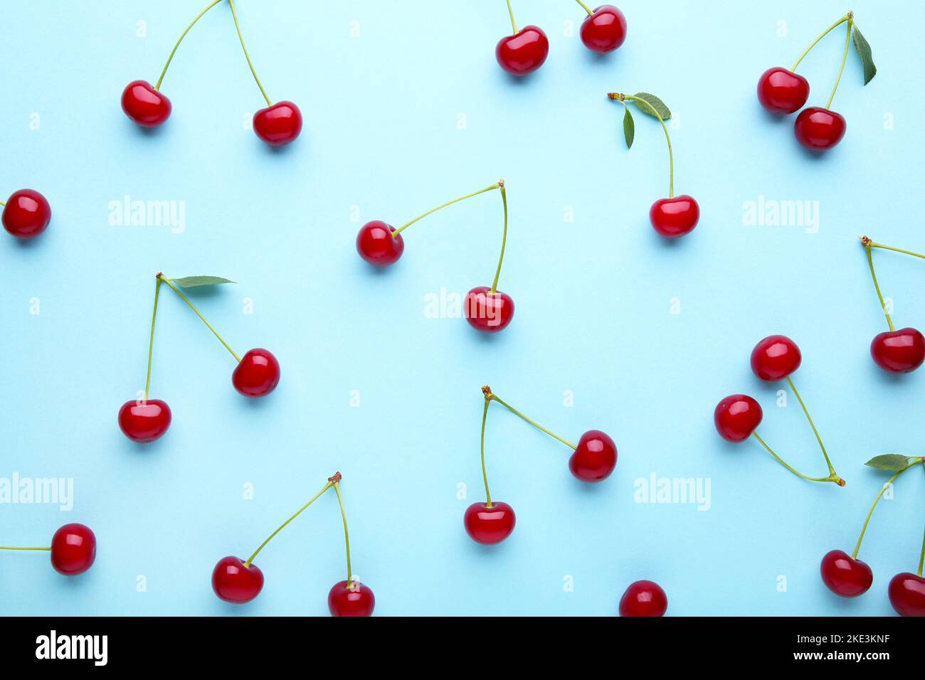 Cherry pattern. Flat lay of cherries on a blue background Stock Photo ...