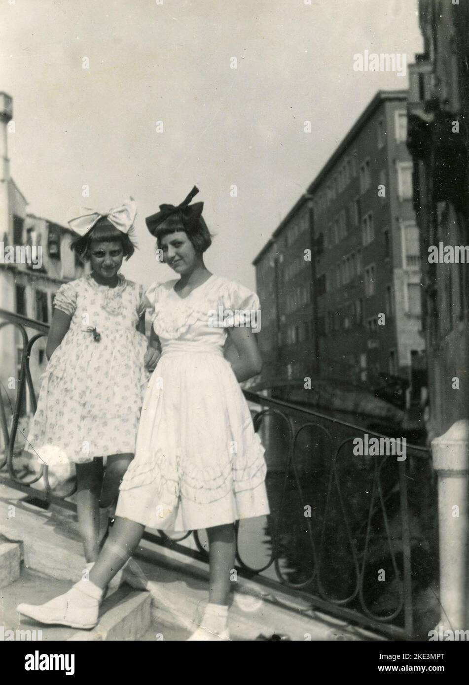 Two girls standing in a bridge of Venice, Italy 1950s Stock Photo - Alamy